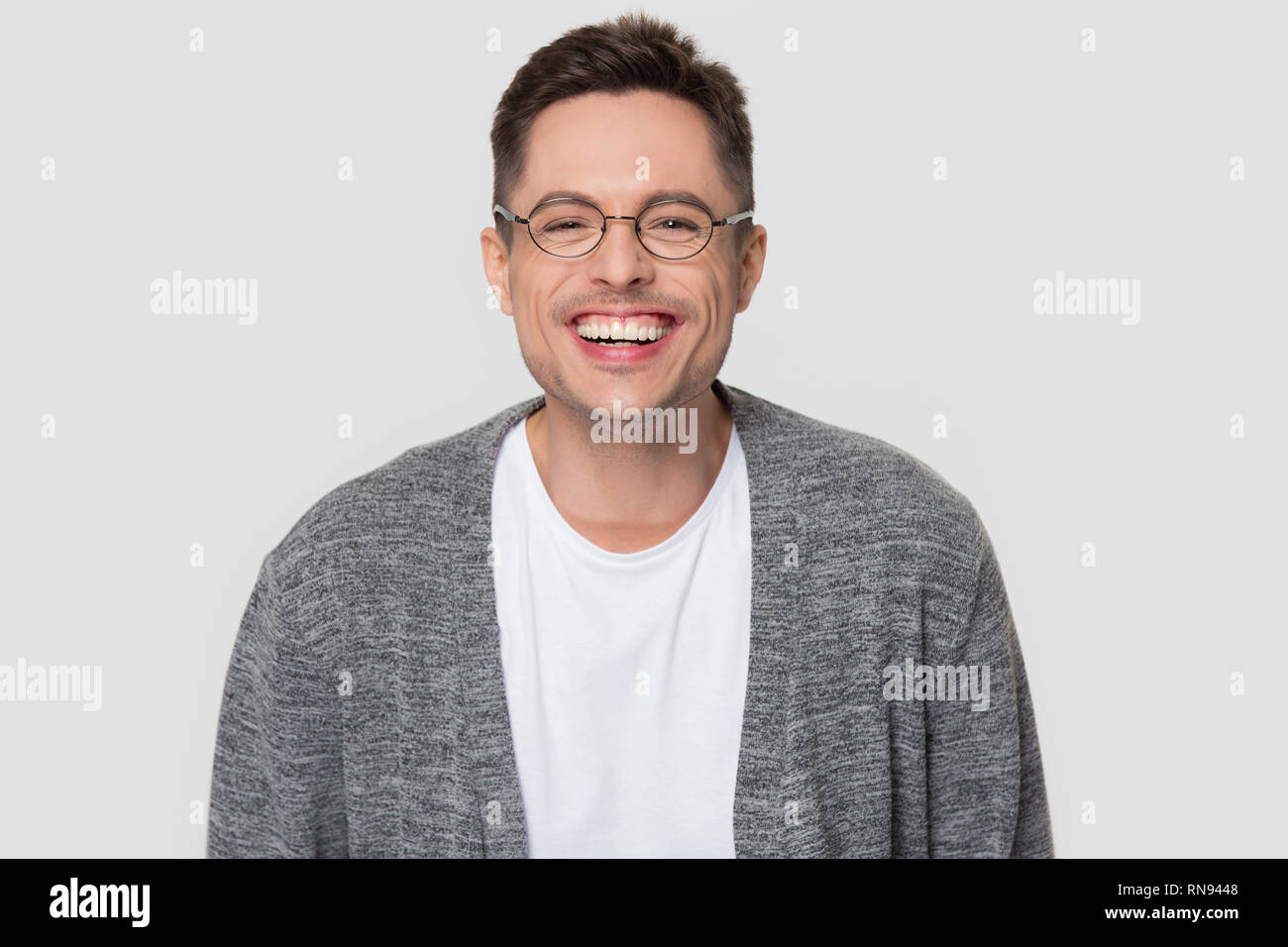 Funny happy millennial man wearing glasses laughing looking at camera ...