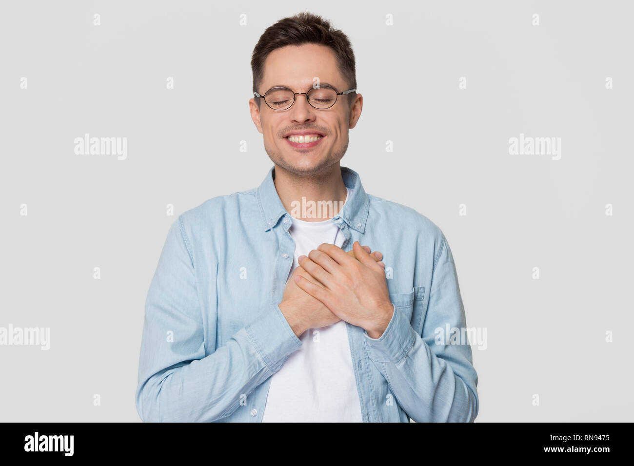 Grateful happy man holding hands on chest feeling appreciation Stock ...
