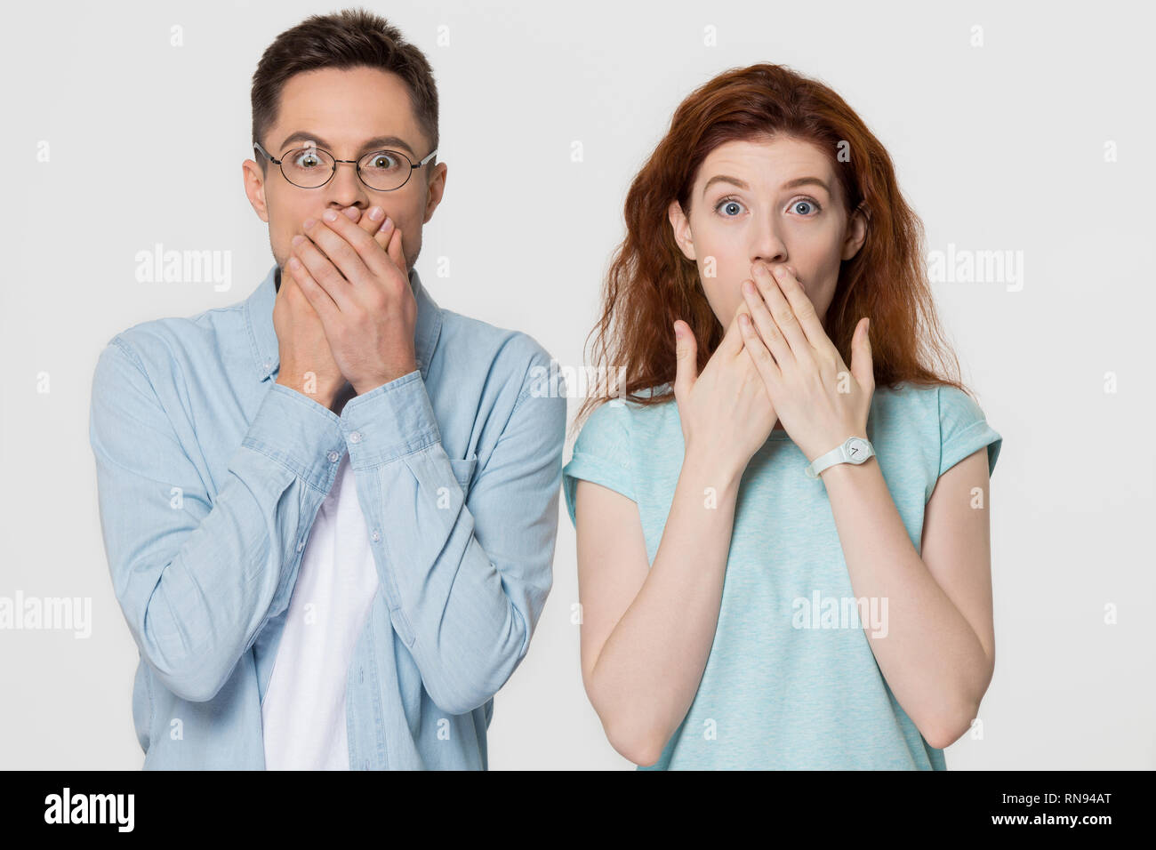 Shocked Scared Couple Covering Mouth With Hands Looking At Camera Stock