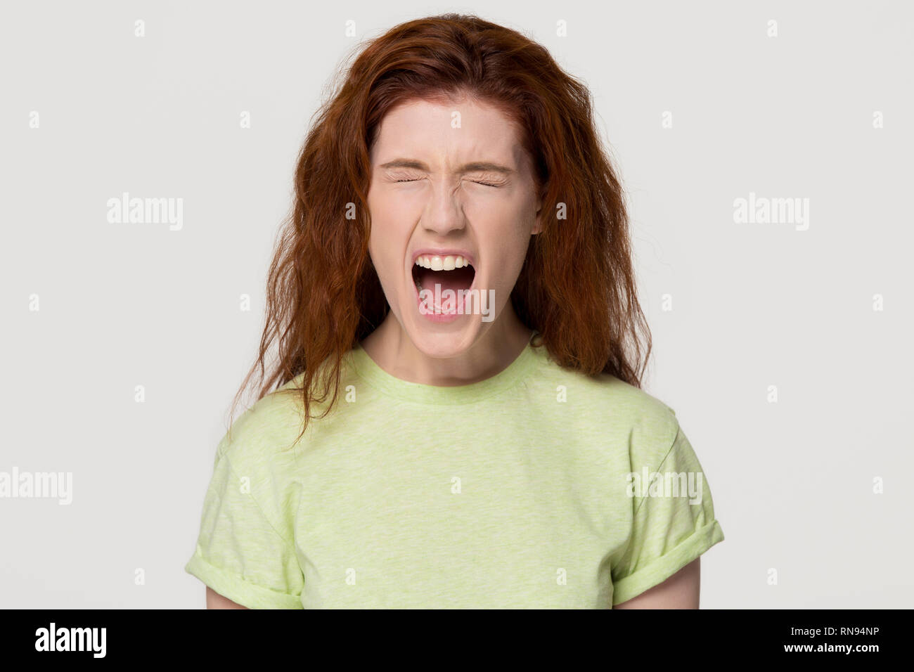Angry stressed redhead woman screaming yelling loud isolated on ...