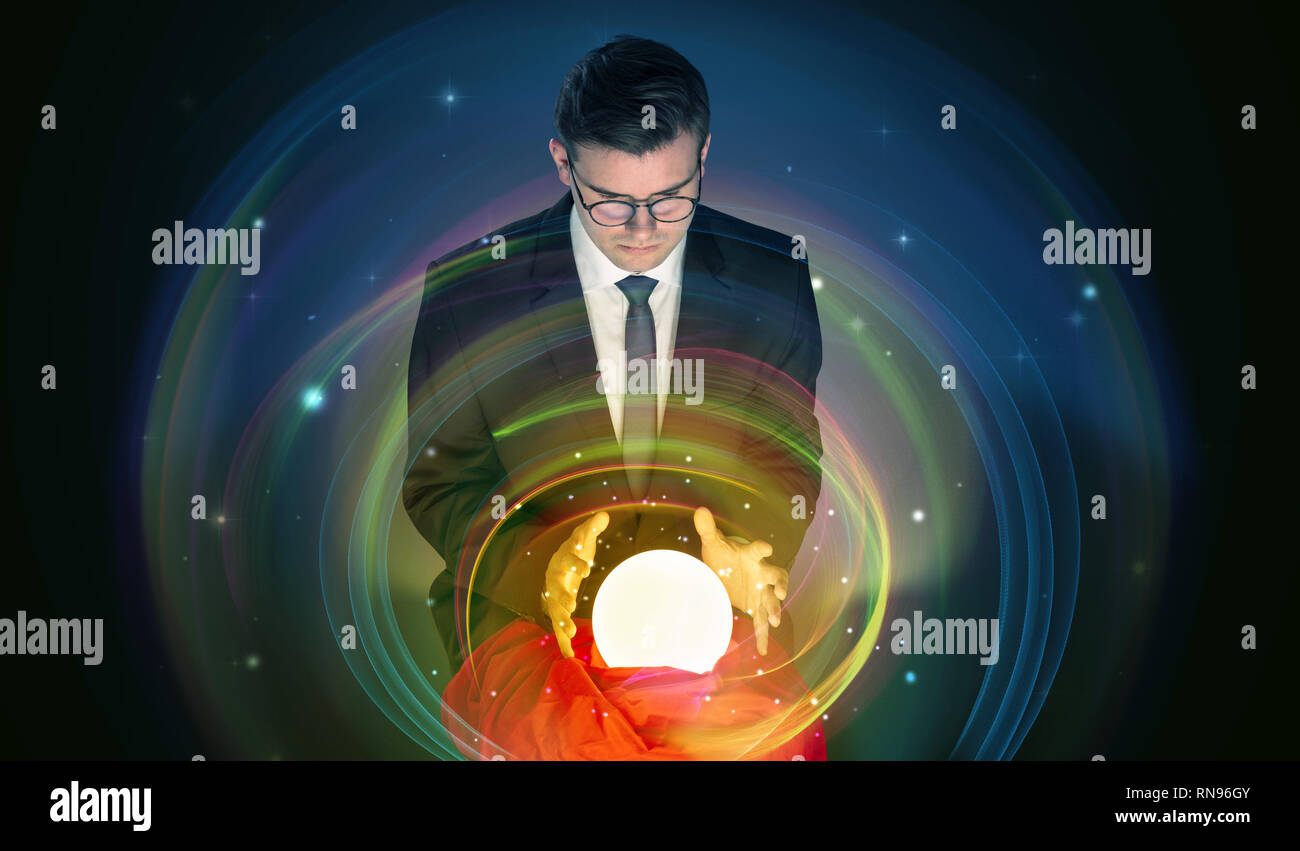 Young handsome man looking to the future of the universe in a crystal ...