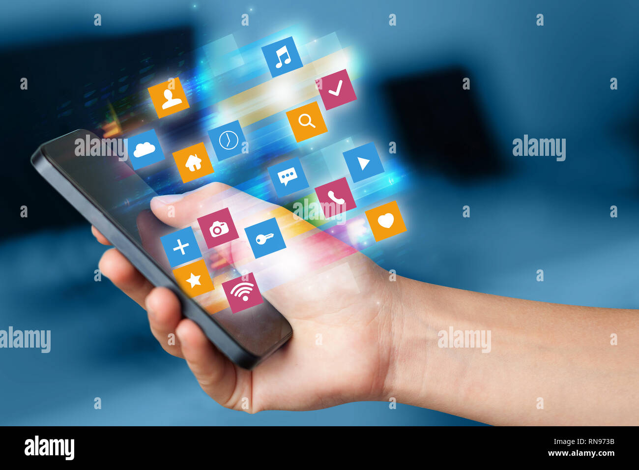 Hand using phone with colorful fast moving application icons and ...