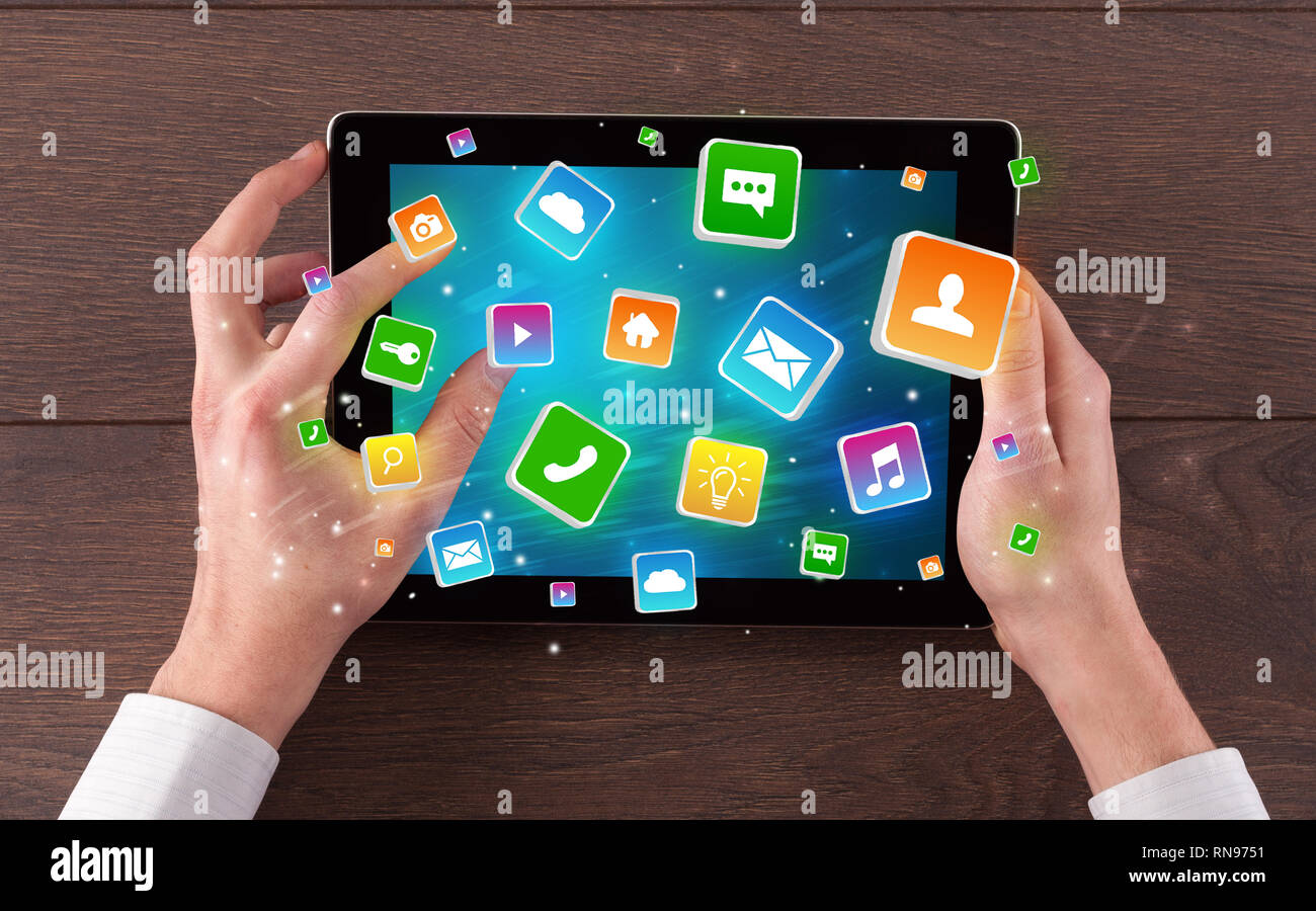 Hand using tablet with colourfull bounce application symbols and icons ...
