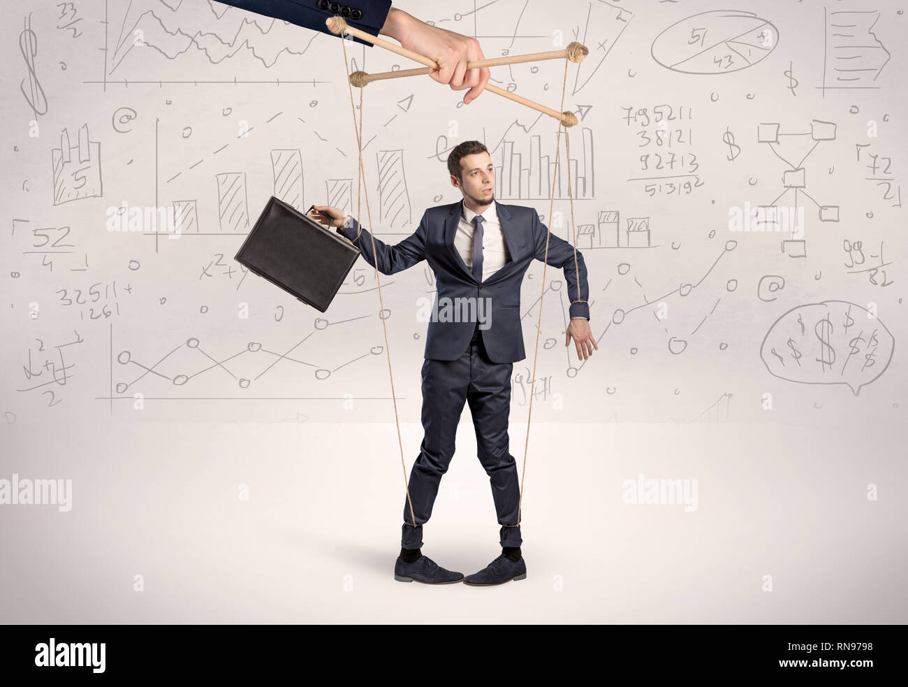 Puppet employee controlled by a big hand with documents and staffs ...