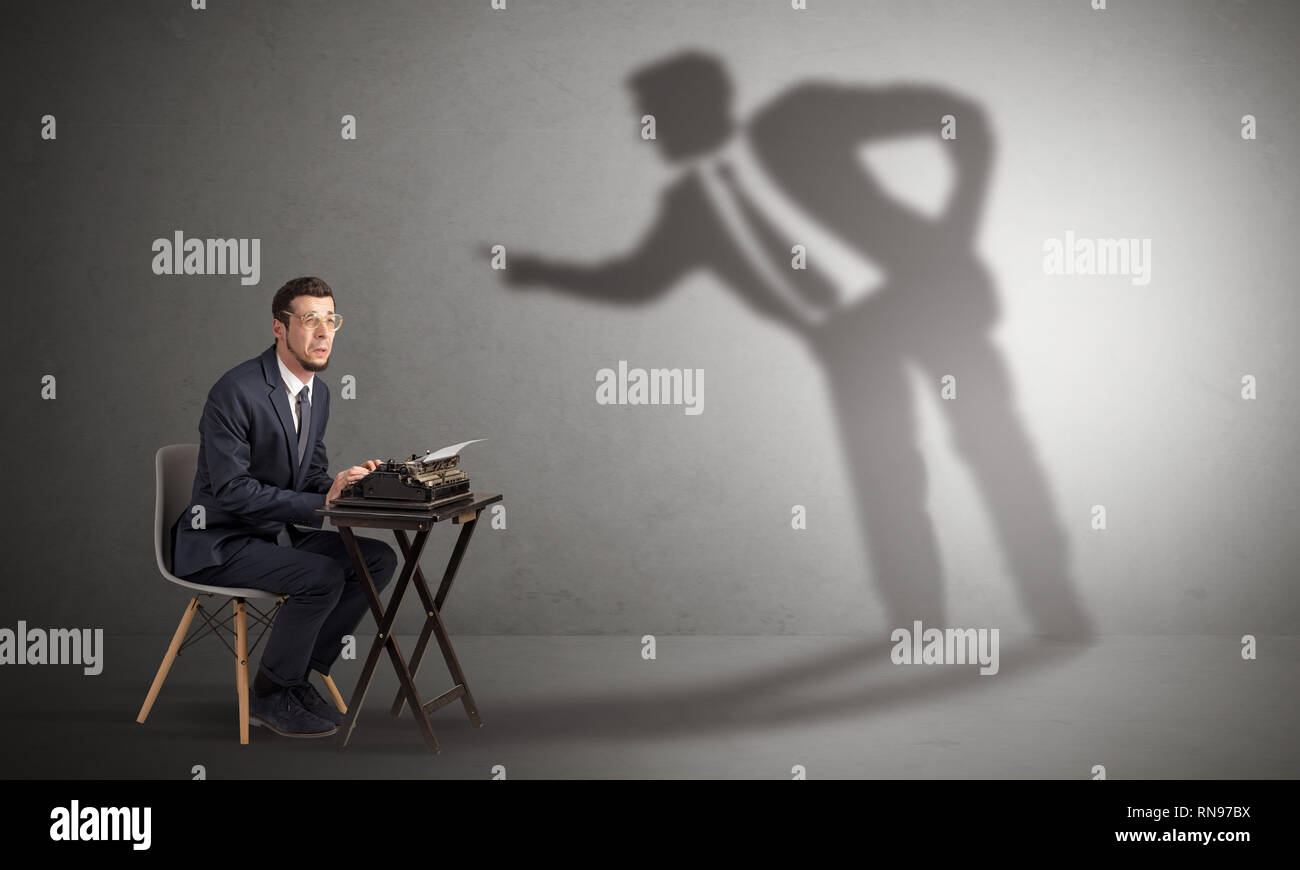Little man working and a big shadow arguing with him Stock Photo - Alamy