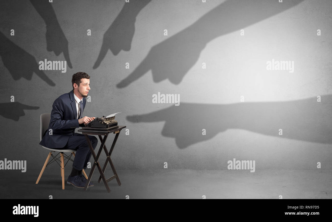 Shadow hand pointing at a small afraid worker Stock Photo - Alamy