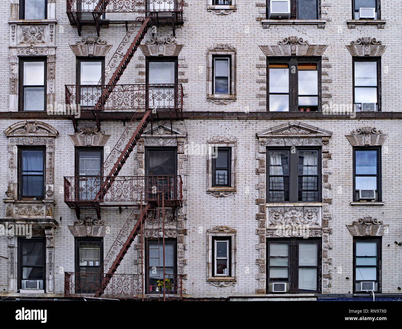 old New York apartment building with external fire escapes, window air ...