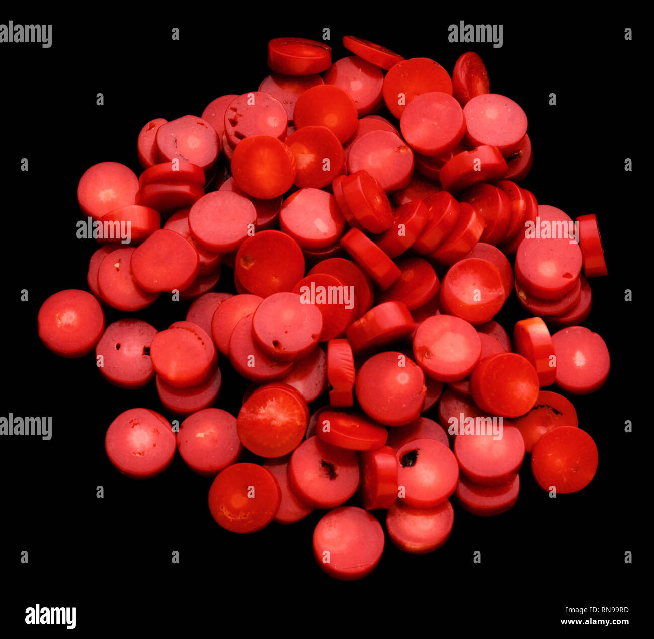 Natural red coral flat circled beads isolated on a black background ...