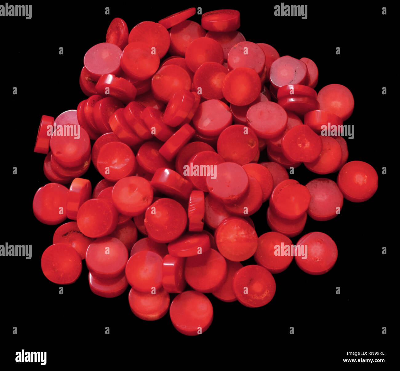 Natural red coral flat circled beads isolated on a black background ...