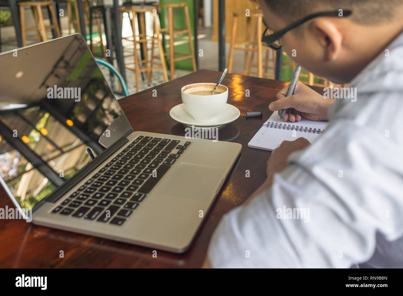 Side view of young man writing diary Stock Photo - Alamy