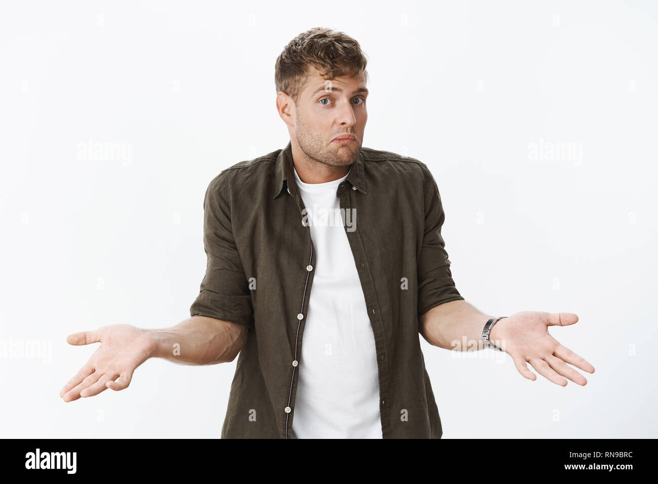 Clueless guy shrugging shoulders as being unaware. Portrait of confused ...