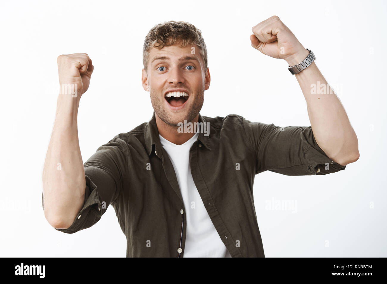 Optimistic and excited charismatic blond guy with blue eyes and white ...