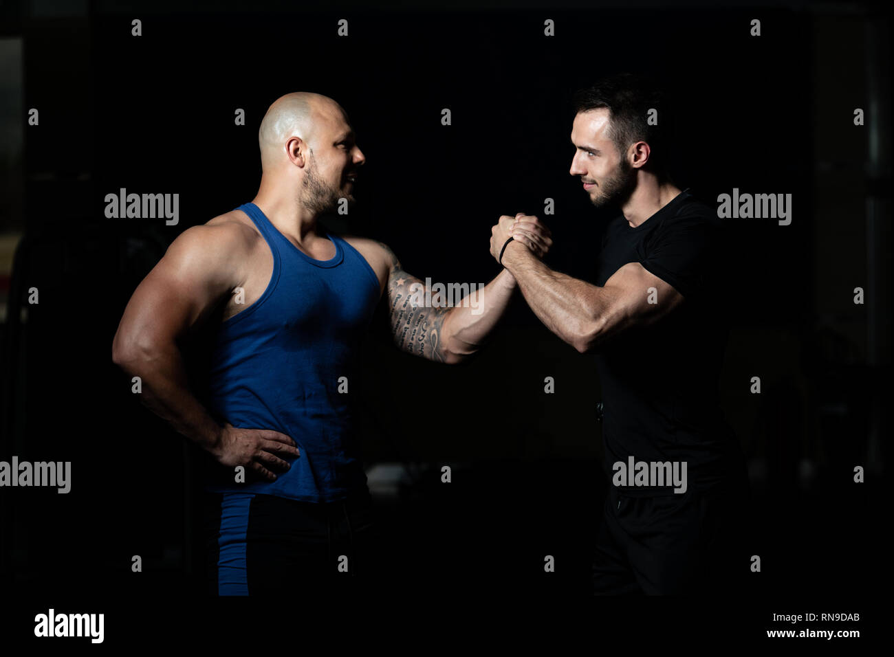 Portrait Of A Man Couple In The Gym With Exercise Equipment Shaking ...