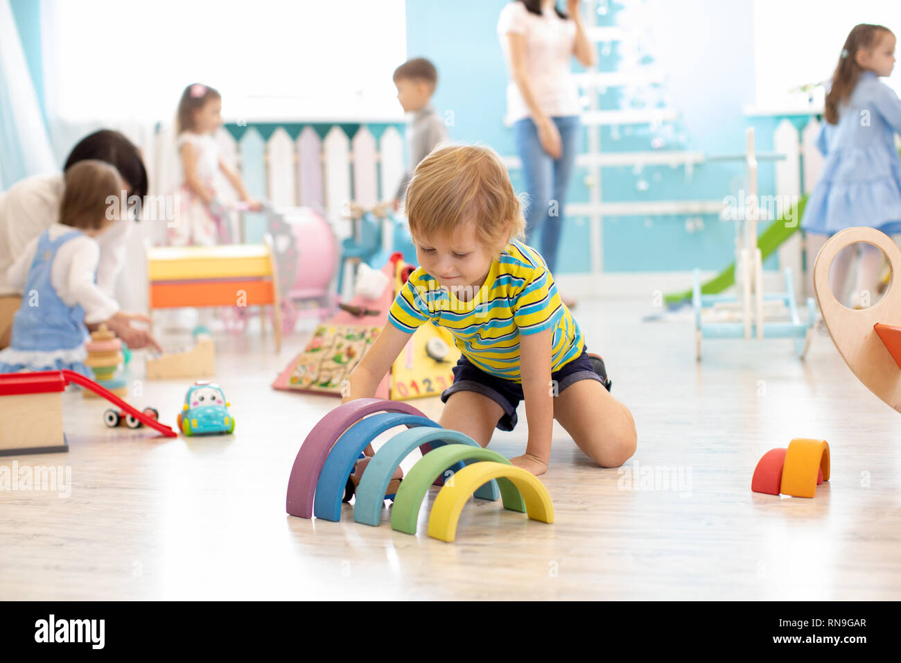 Kids playing on floor with educational toys. Toys for preschool and ...