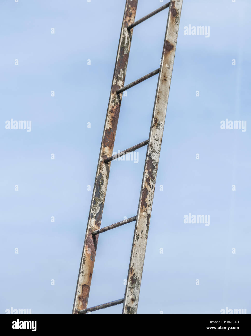 Rusty metal ladder against blue sky. Metaphor 'Career Lader'. Metaphor ...