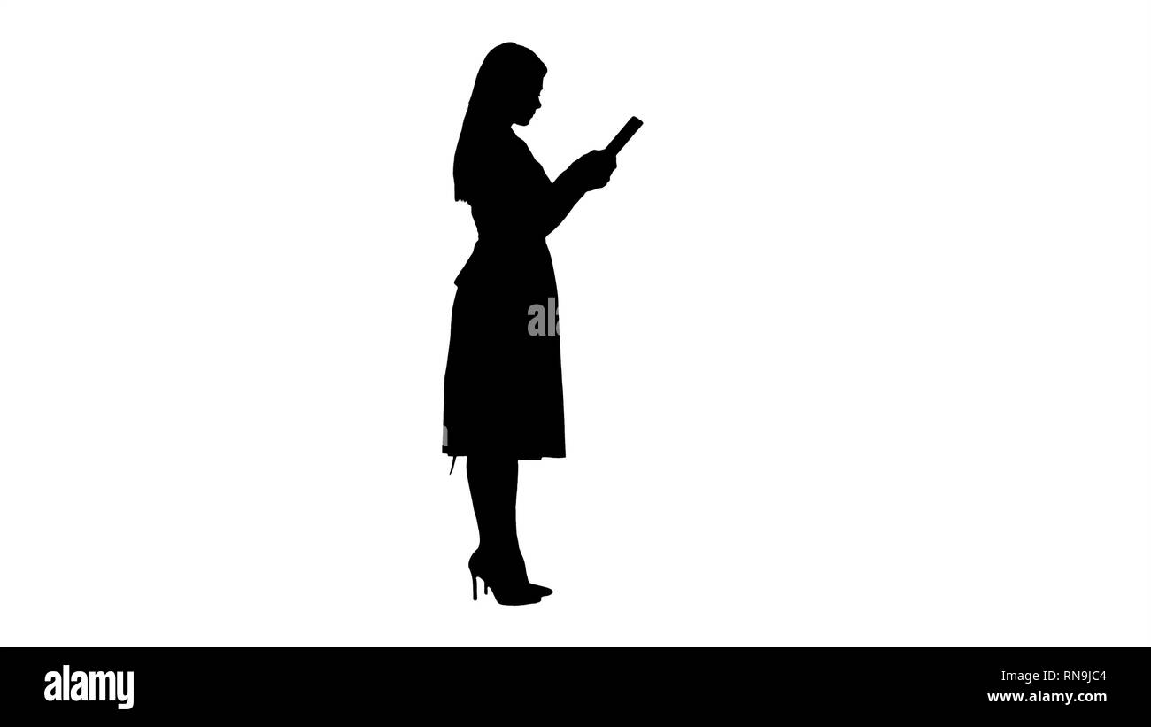 Silhouette Young woman in pink dress side view using tablet Stock Photo ...