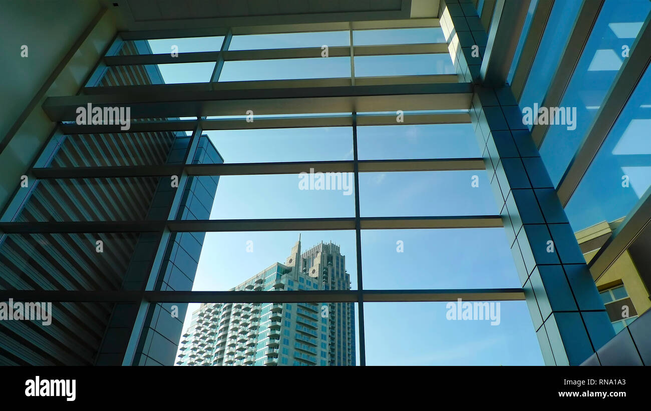 A framed view of a modern high-rise mix-use building from across the ...