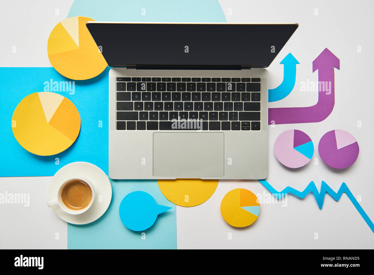 top view of laptop with cup of coffee, paper charts and graph, pointers ...