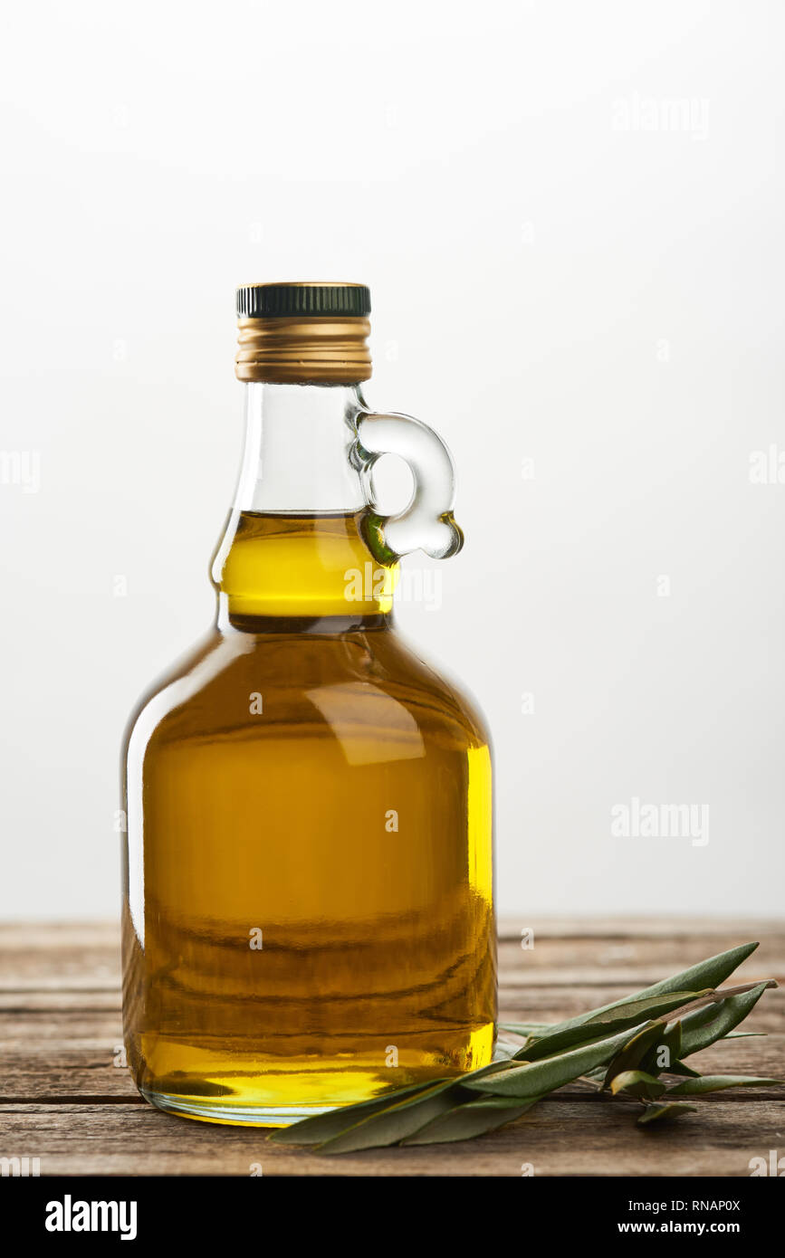 bottle of oil and olive tree leaves isolated on grey Stock Photo - Alamy