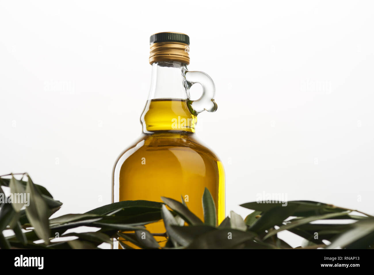 olive tree leaves and bottle of oil isolated on grey Stock Photo - Alamy