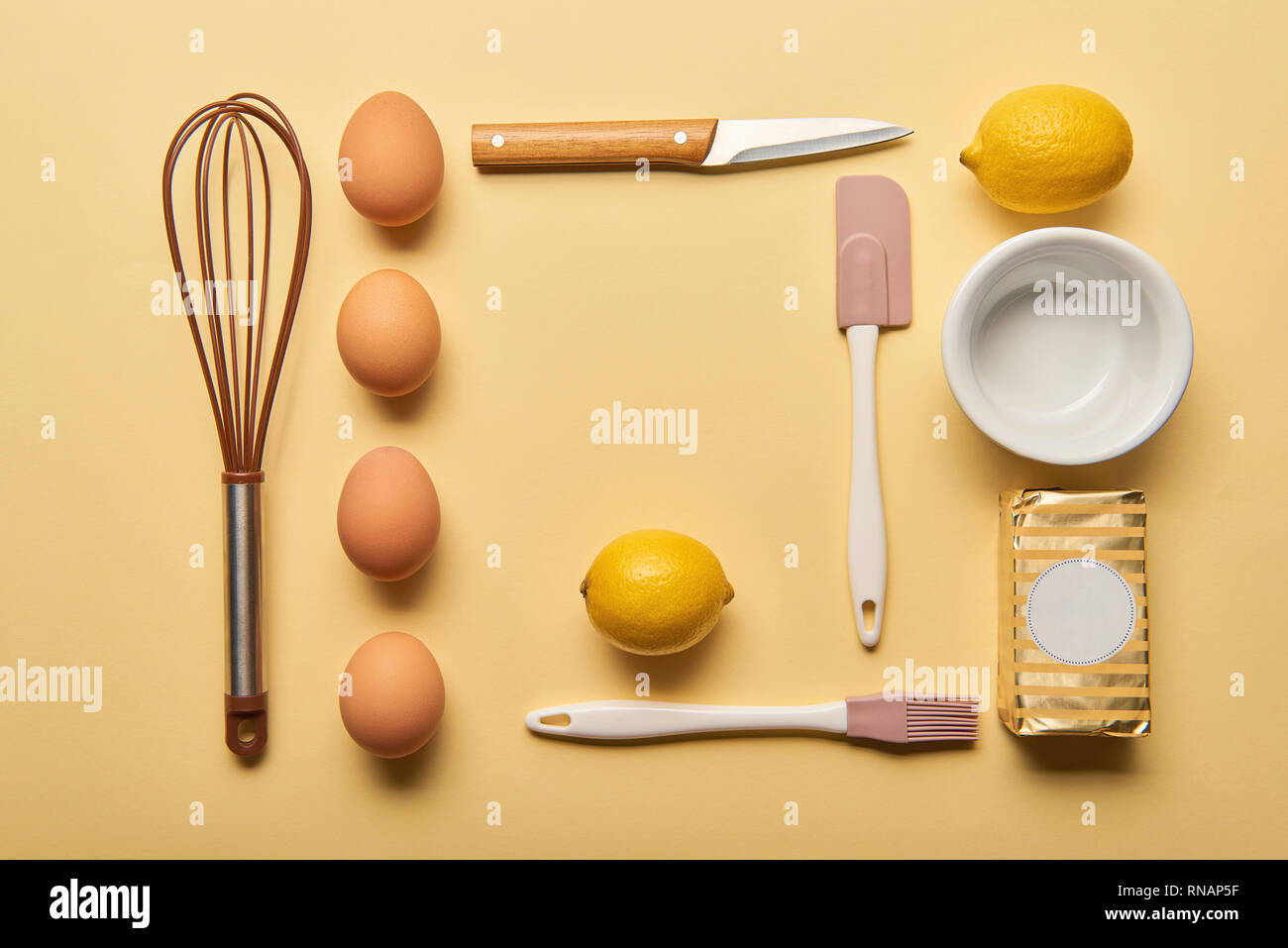 flat lay with cooking utensils and raw ingredients on yellow background ...
