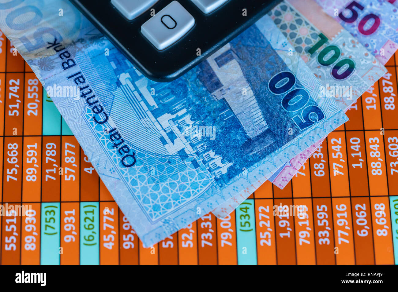 Qatar Riyal Bank Notes on spreadsheet report background With Calculator ...