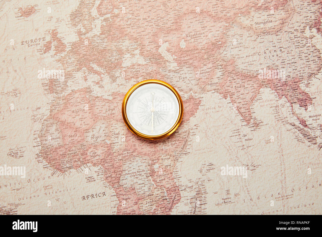 top view of golden compass on vintage world map Stock Photo - Alamy