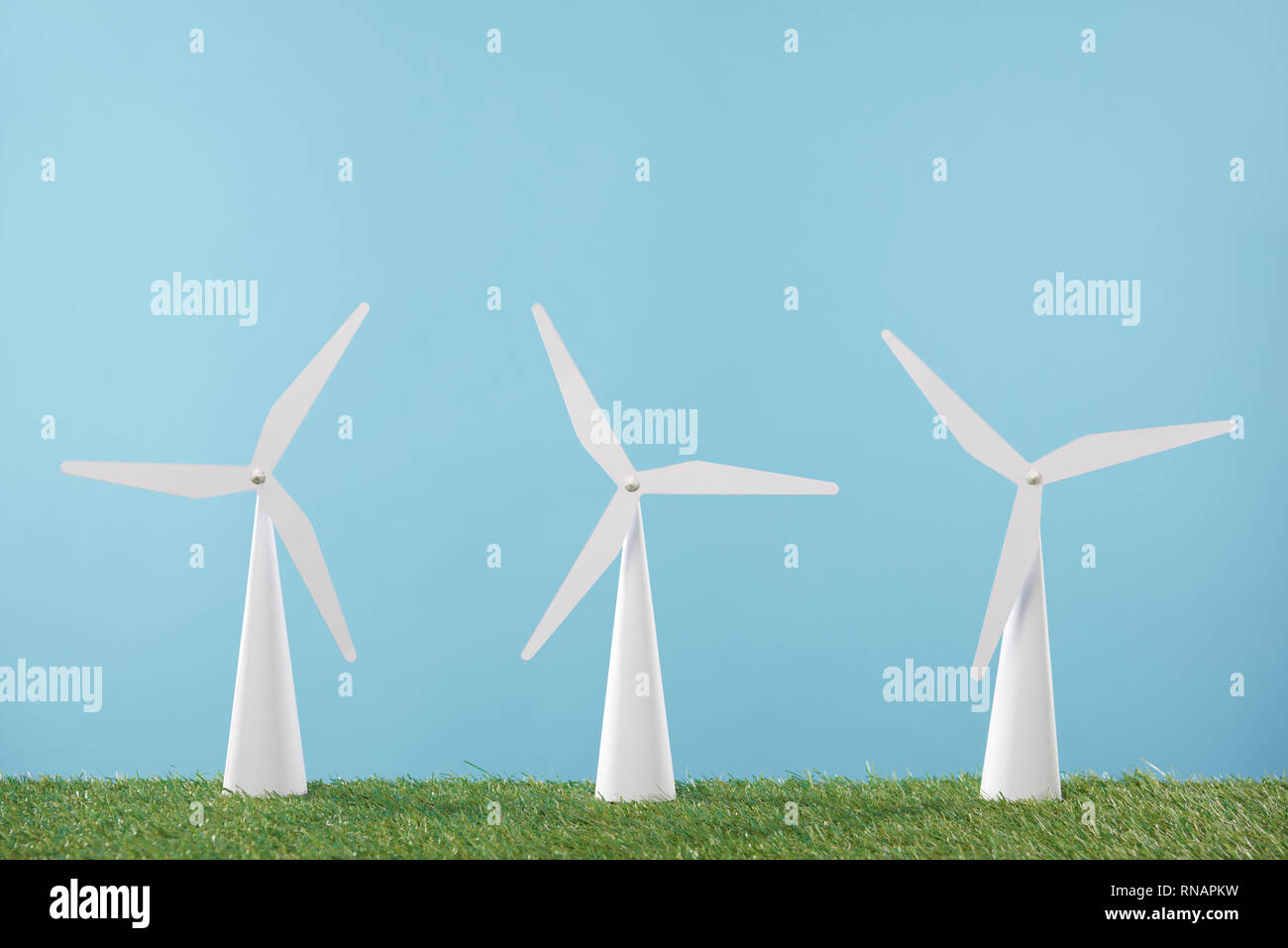 white windmill models on grass and blue background Stock Photo - Alamy