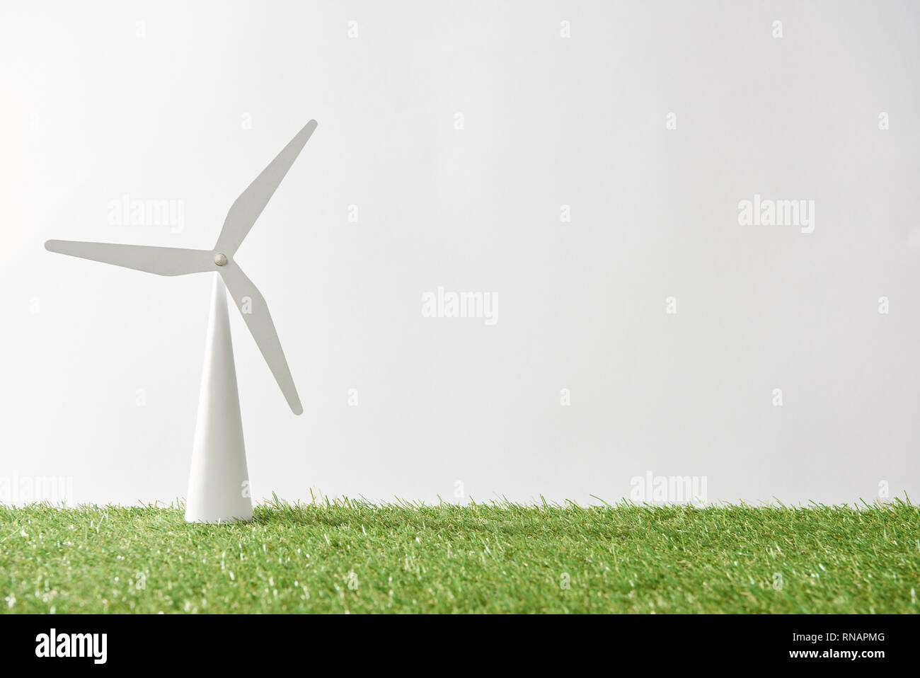 windmill model on green grass and white background with copy space ...