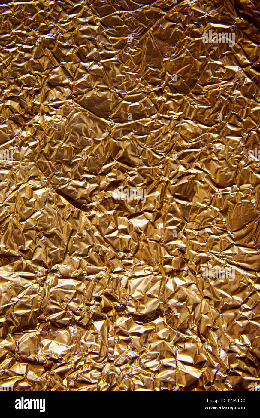 top view of rumpled sheet golden foil with glares Stock Photo - Alamy