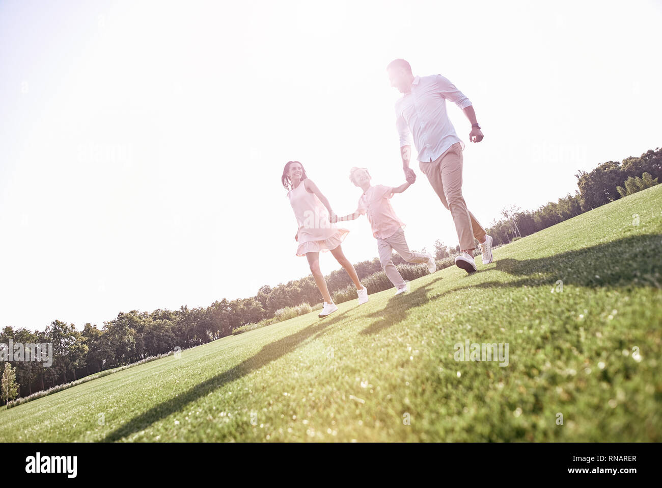 Happy family holding hands running hi-res stock photography and images ...