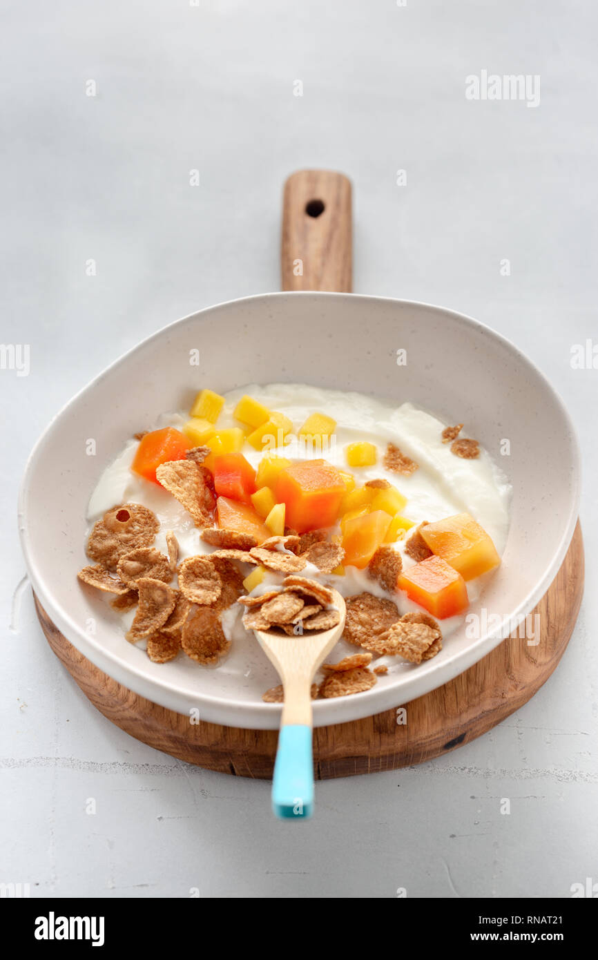 Healthy breakfast. Multigrain flakes with greek yogurt and fruits mango ...