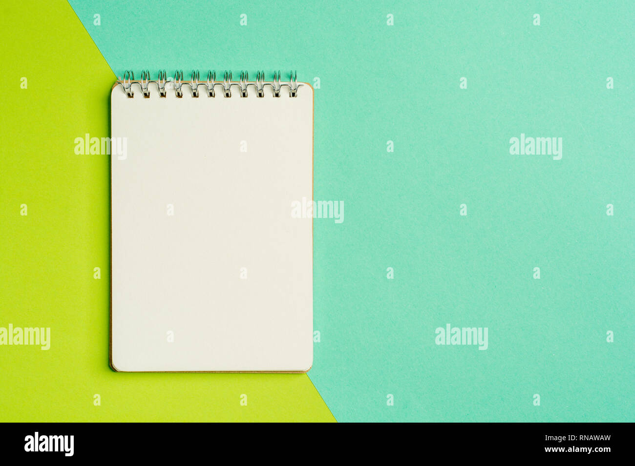 Top view of spiral notepad on colored surface. Flat lay style with ...