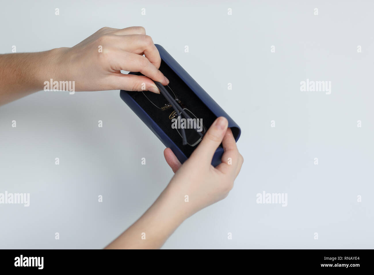 Hand holding glasses and blue case isolated on white background Stock ...