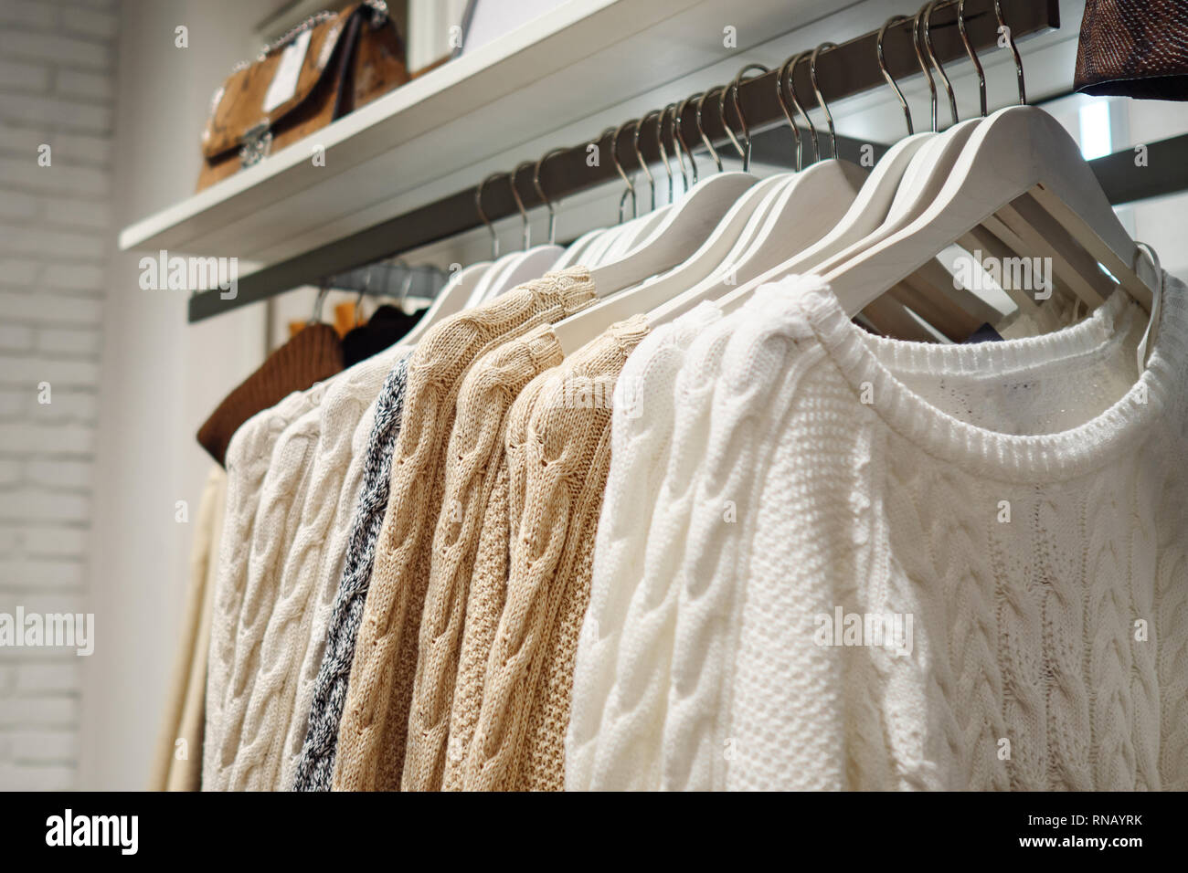 Stylish multicolored sweaters on rack Stock Photo - Alamy