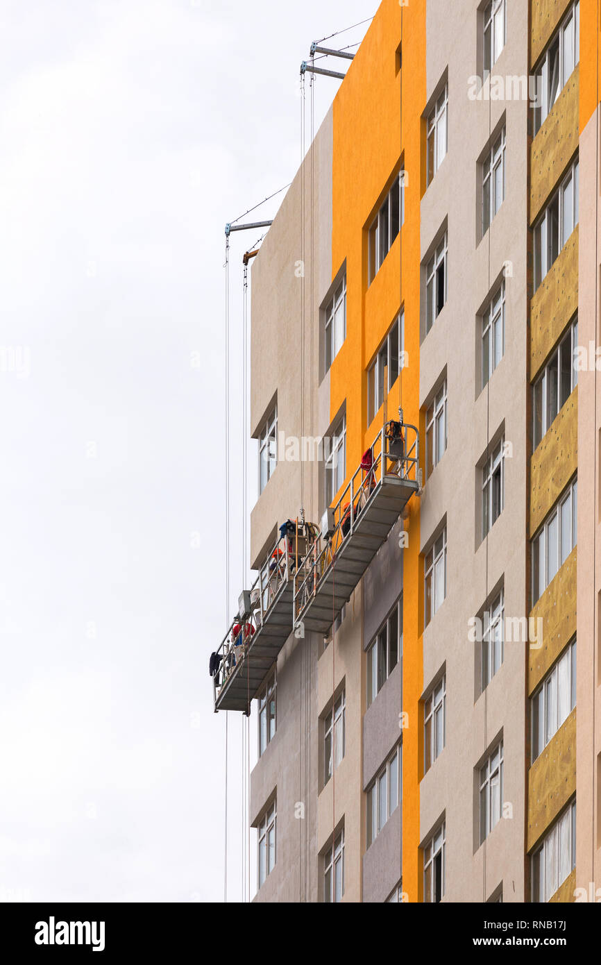 Builders paint the facade of a high-rise residential building Stock ...