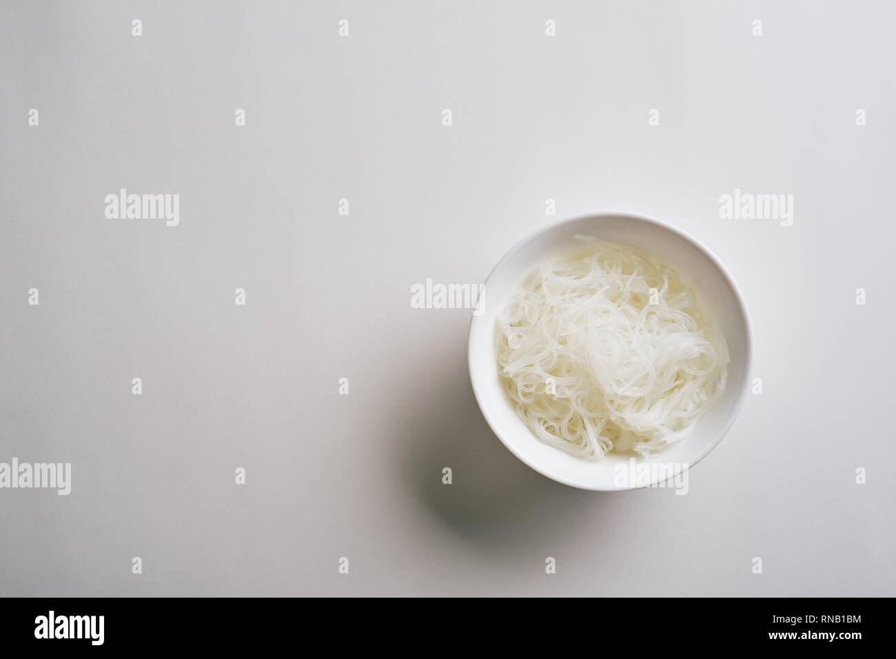 Rice noodles in a plate. Boiled rice noodles in a plate on a white ...