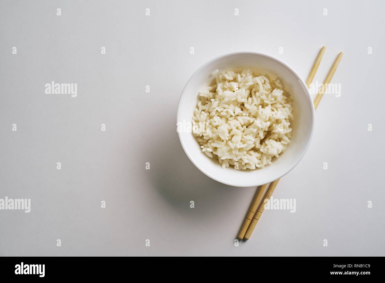 top view of boiled rice with chopsticks isolated on white background ...