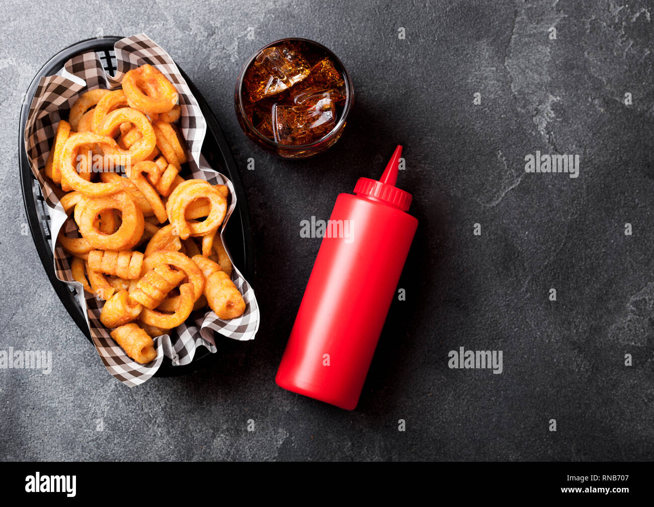 Curly fries fast food snack in red plastic tray with glass of cola and ...