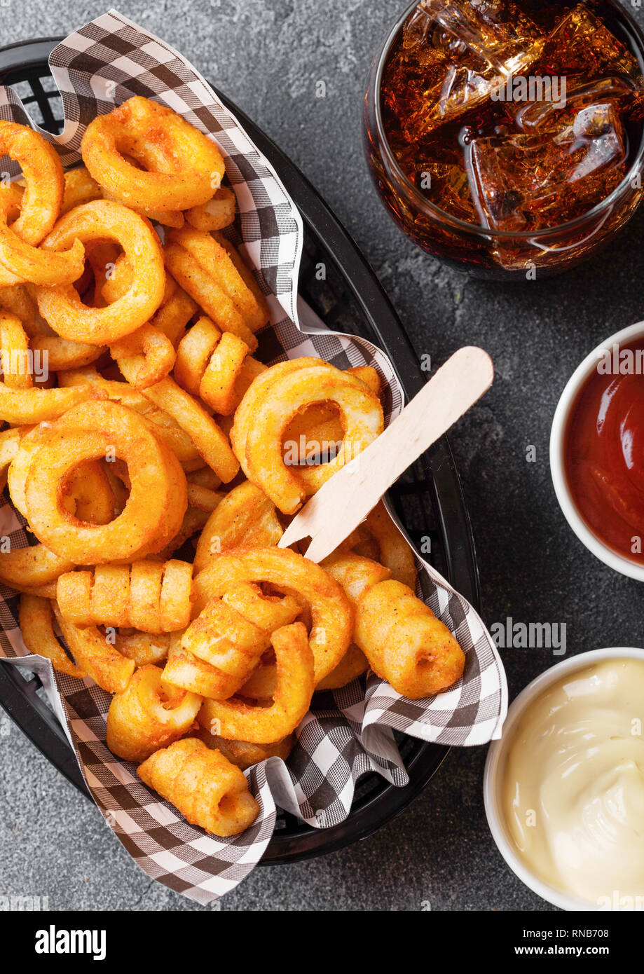 Curly fries fast food snack in red plastic tray with glass of cola and ...