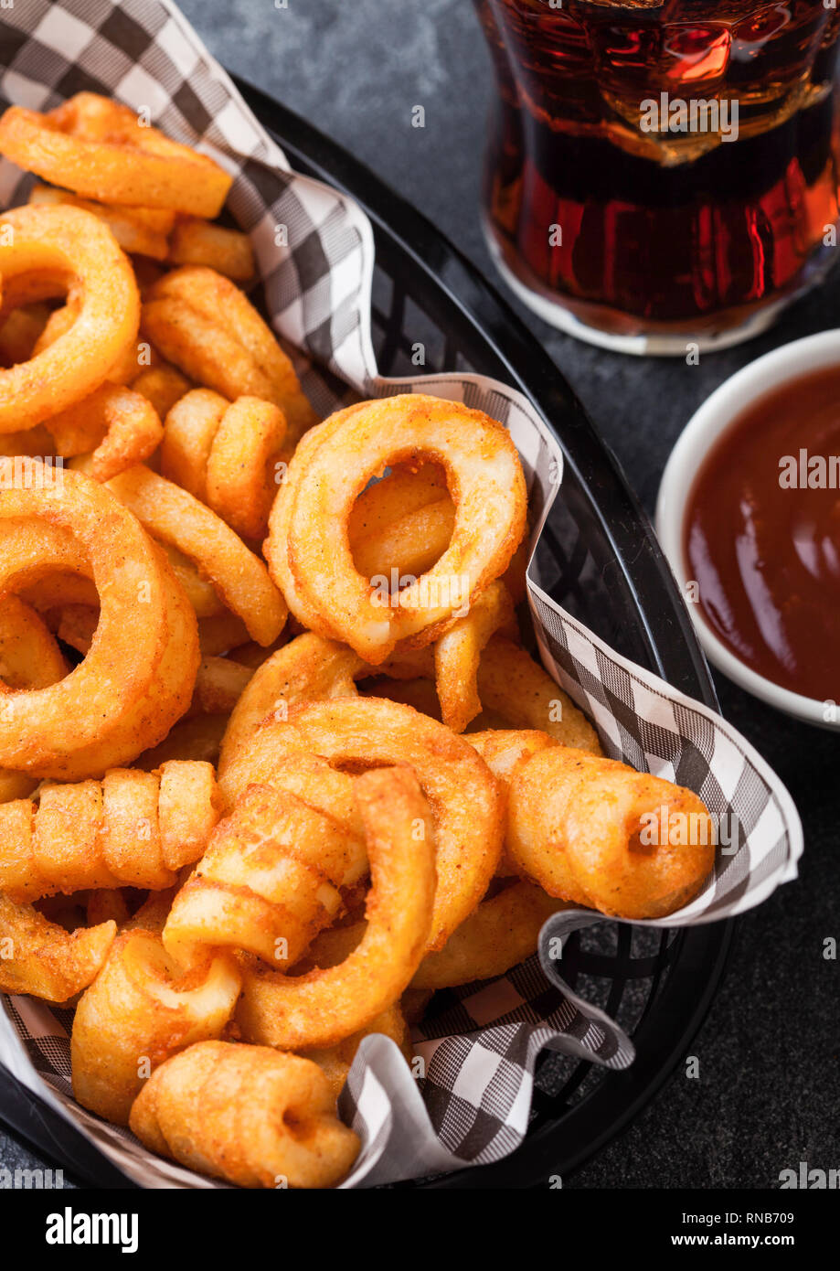 Curly fries fast food snack in red plastic tray with glass of cola and ...