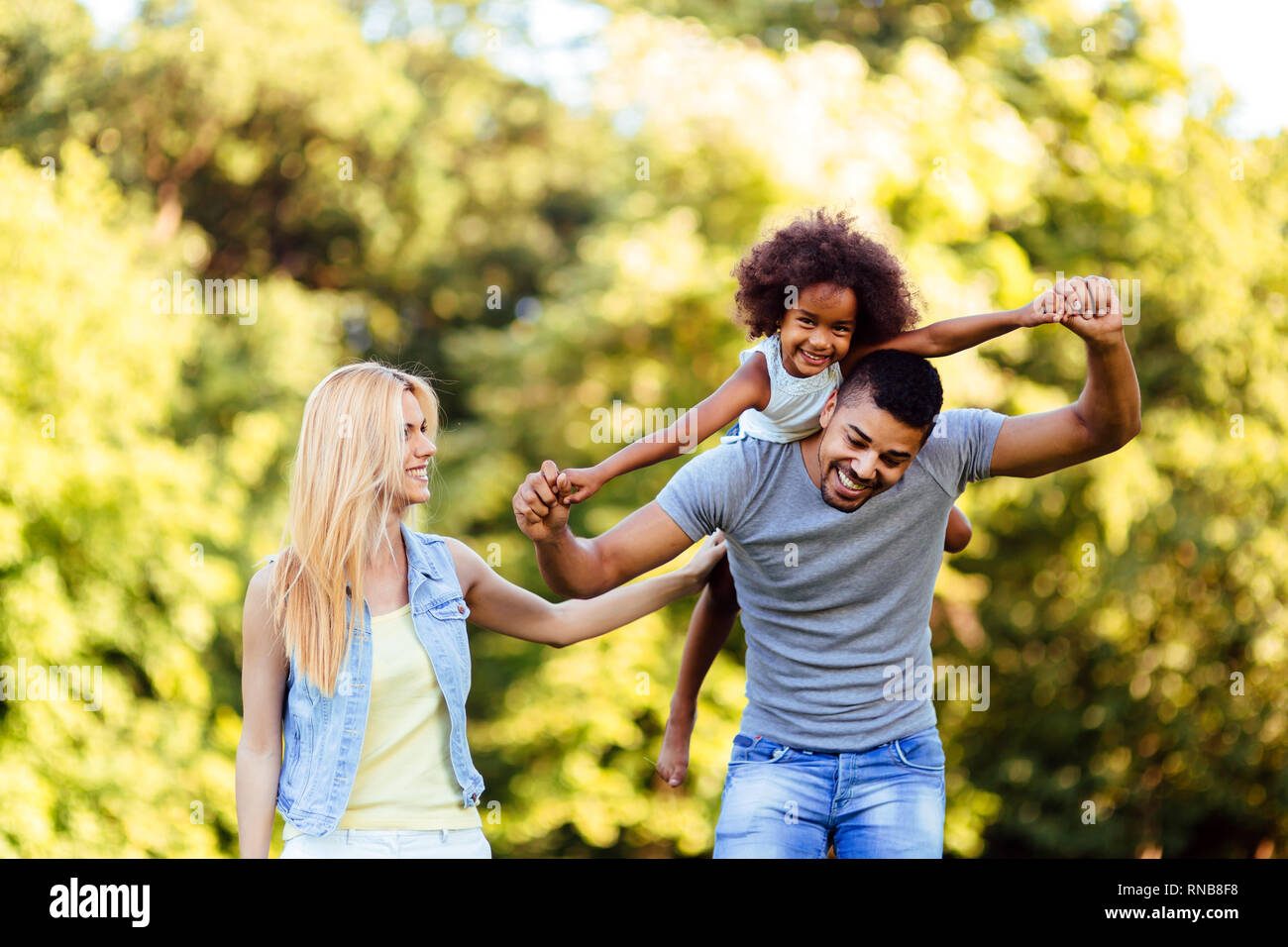 Picture of happy young couple spending time with their daughter Stock ...