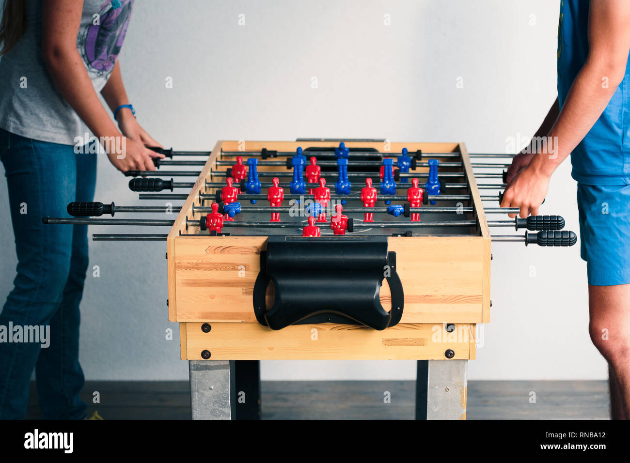 Young teenager boy playing table football with another player. Young ...