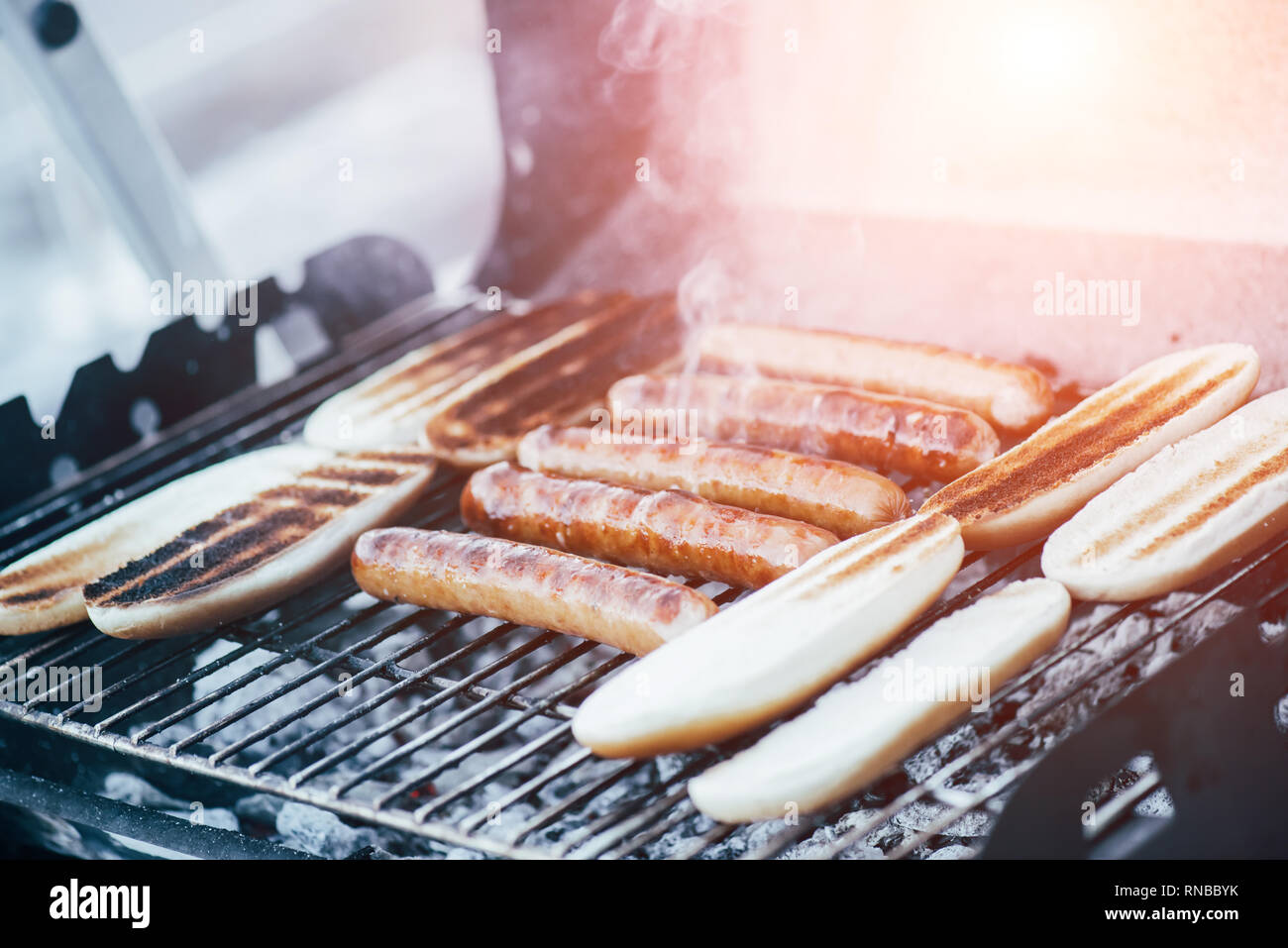 delicious hot dogs grilling with smoke on barbecue grill grade Stock ...