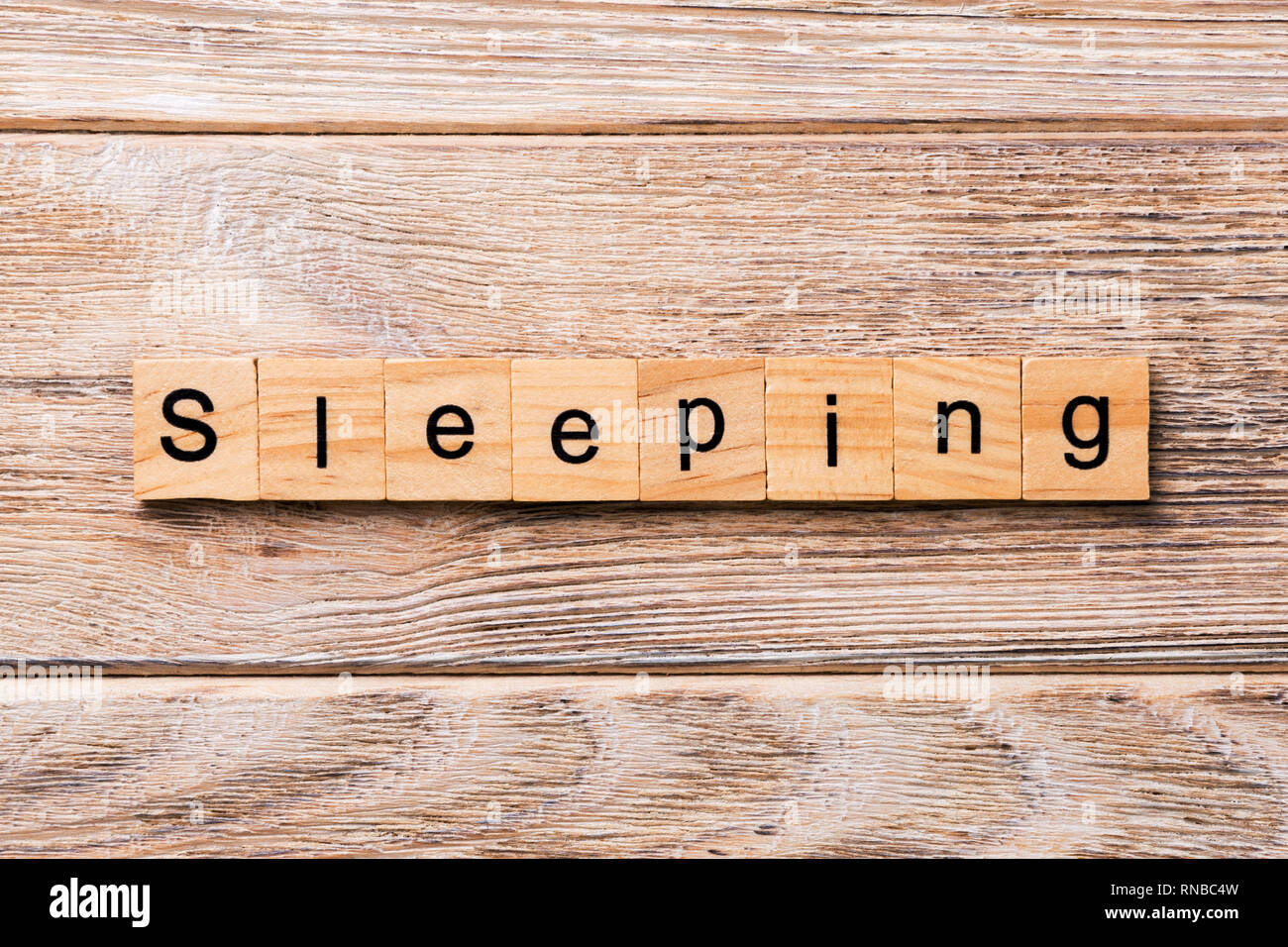 SLEEPING word written on wood block. SLEEPING text on wooden table for ...
