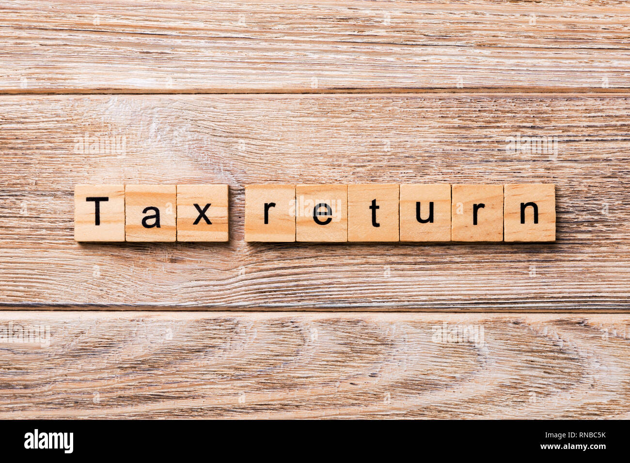 tax return word written on wood block. tax return text on wooden table ...