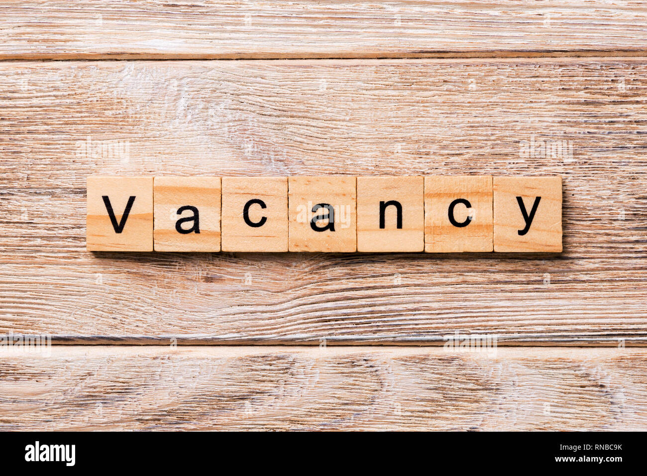 Vacancy word written on wood block. Vacancy text on wooden table for ...