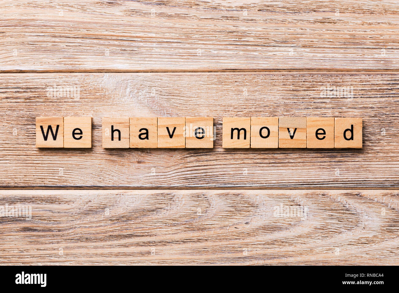 we have moved word written on wood block. we have moved text on wooden ...