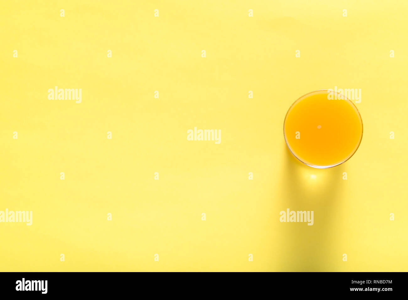 Glass of fresh juice, top view. Orange juice on yellow background Stock ...
