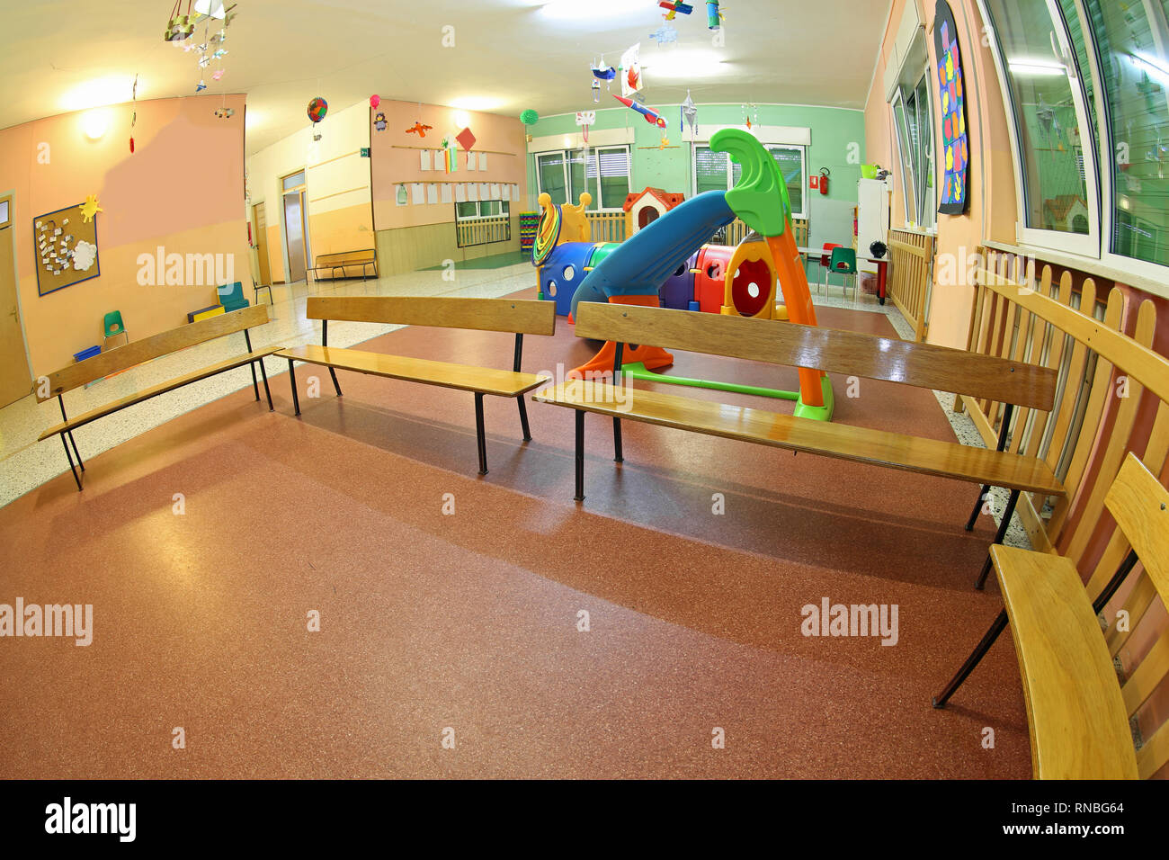 inside the large hall of a kindergarten with benches to seat the ...